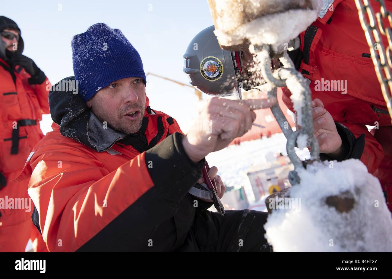 ARCTIC OCEAN – Peter Koski clears the snow off a series of weights ...