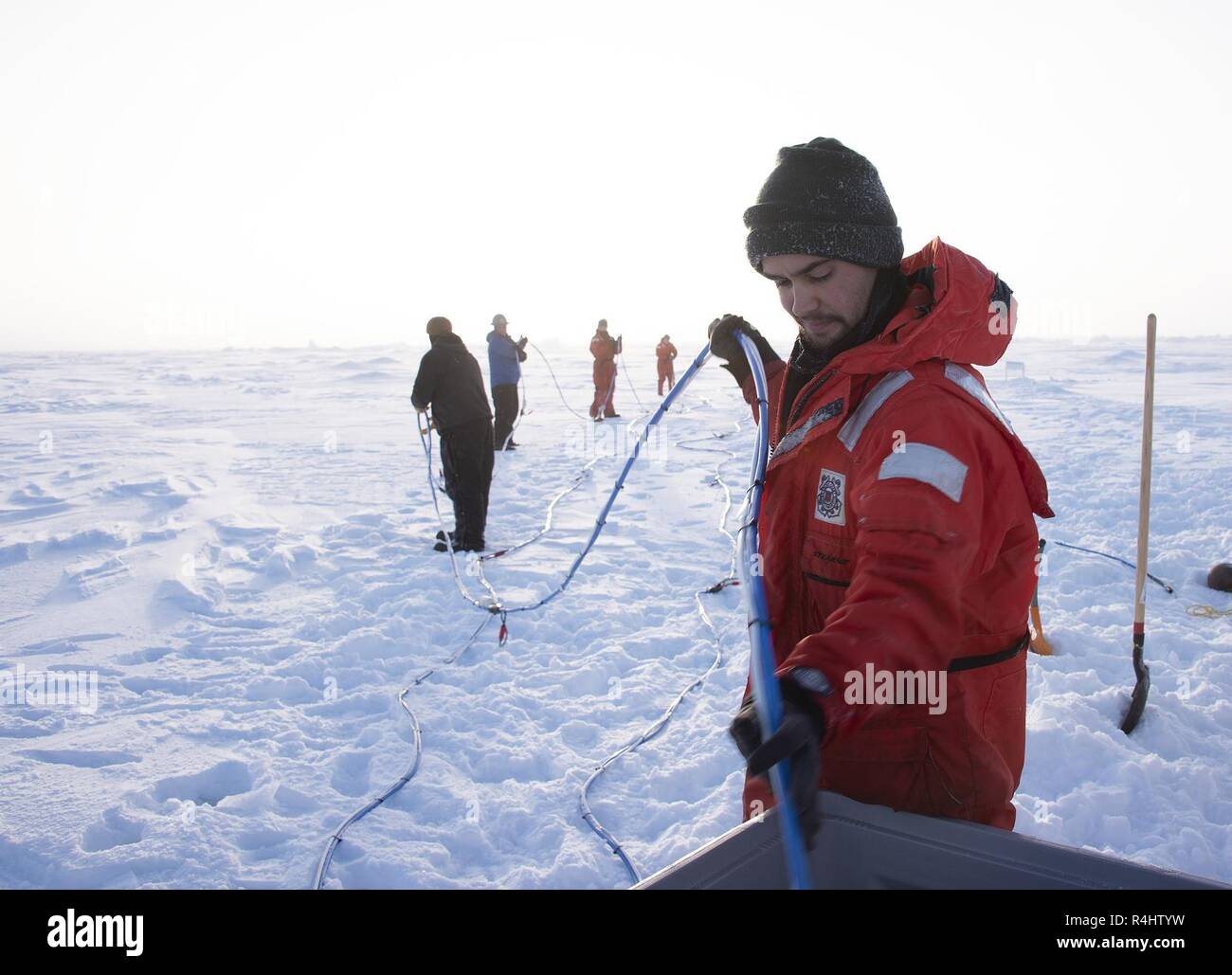 ARCTIC OCEAN – Carl Felton pulls a cable from a box while a team of ...