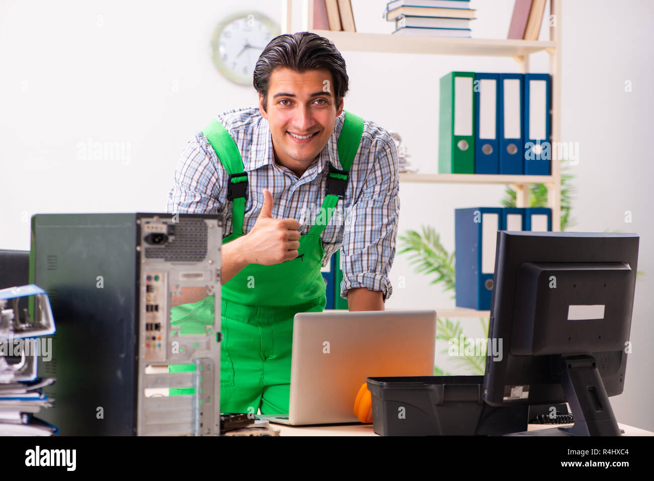 Young engineer repairing broken computer at the office Stock Photo - Alamy