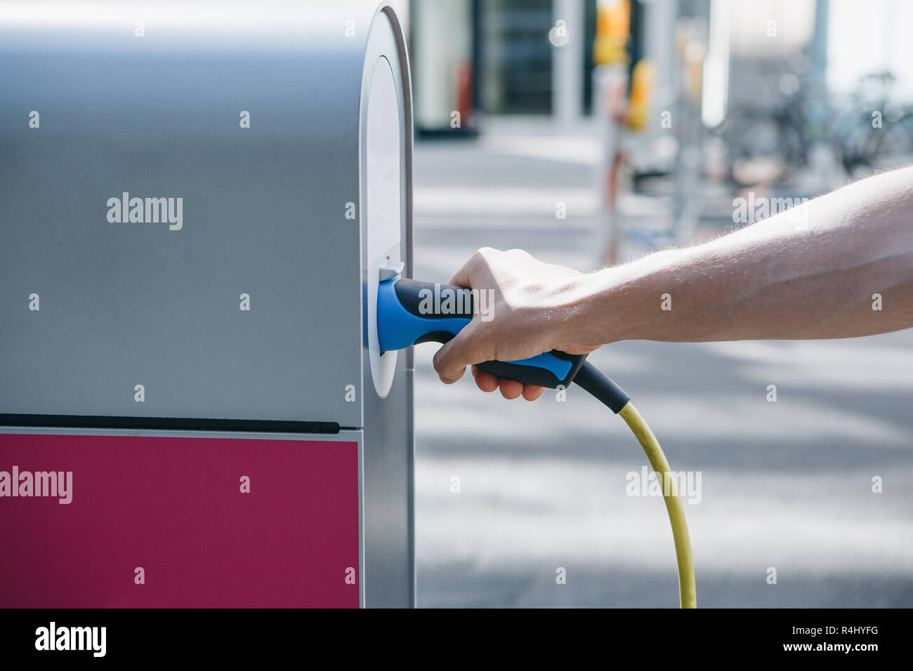 Close-up of a hand inserts a special cord or cable into an outdoor ...