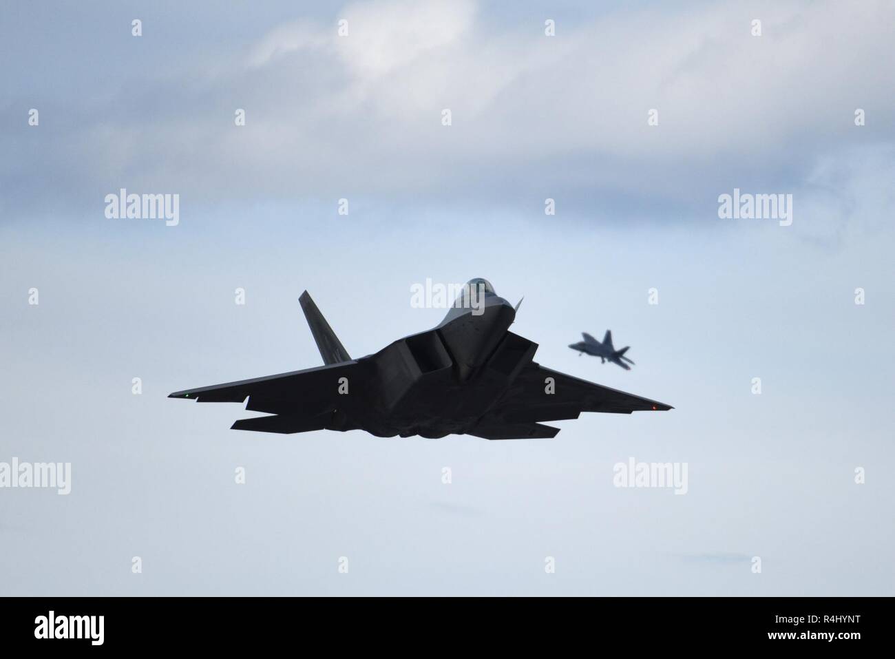A U.S. Air Force F-22 Raptor flies over the runway at Joint Base ...