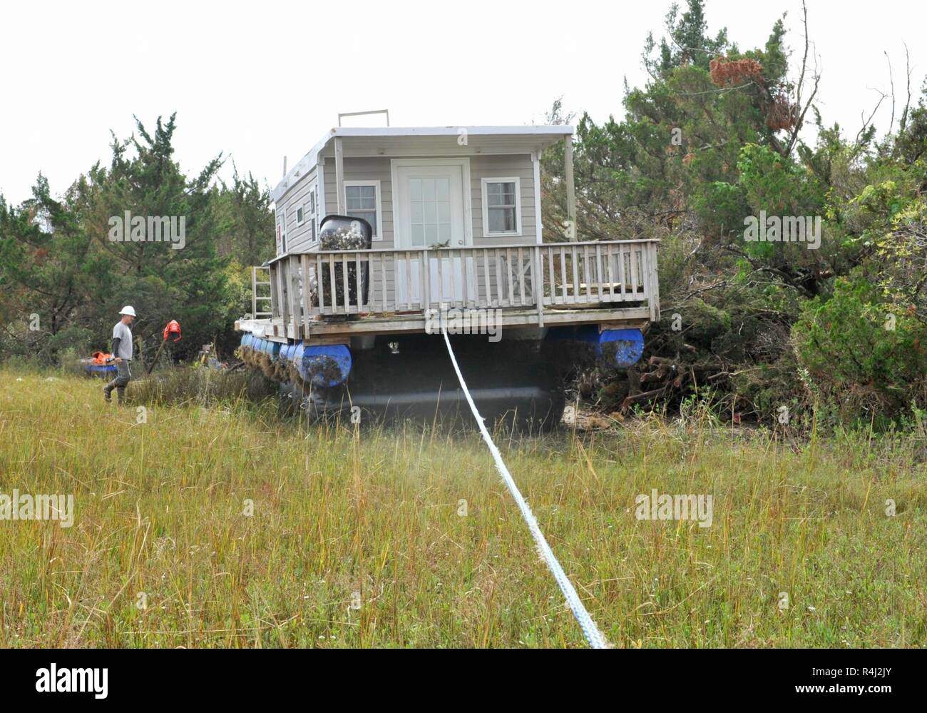 Resolve Marine Group salvage technicians pull a displaced houseboat ...