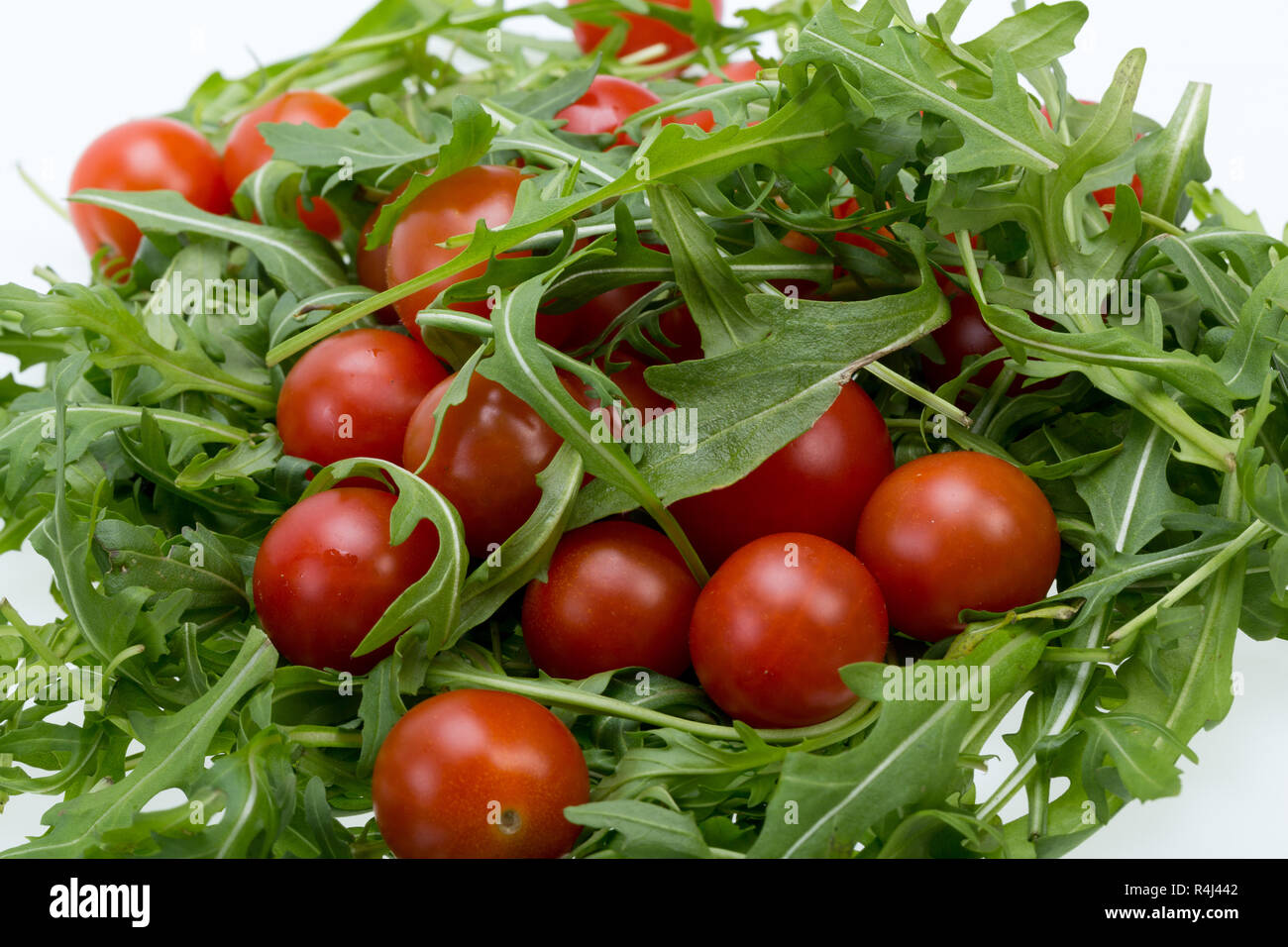 Heap of ruccola leaves and cherry tomatoes Stock Photo - Alamy
