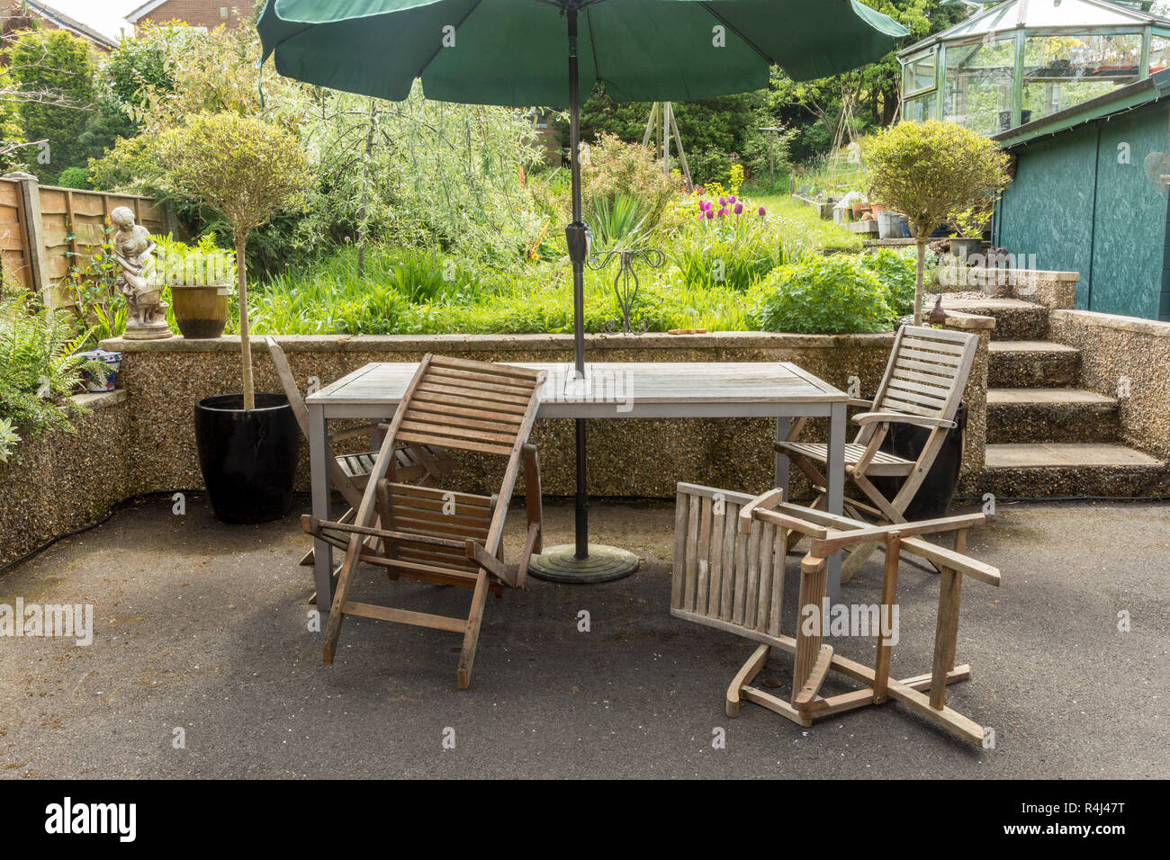 Garden table and chairs pushed over Stock Photo - Alamy