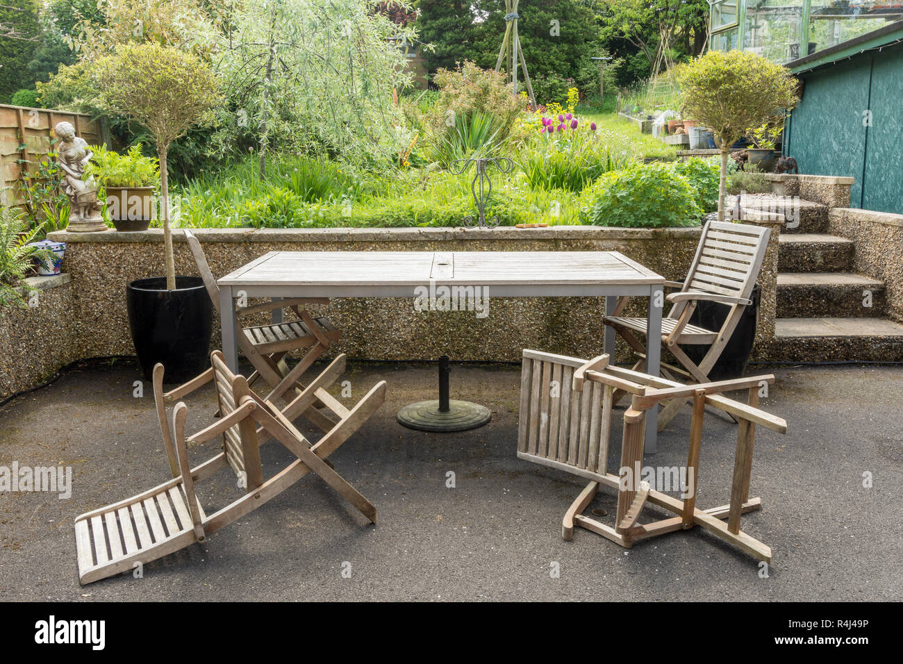 Garden table and chairs pushed over Stock Photo - Alamy