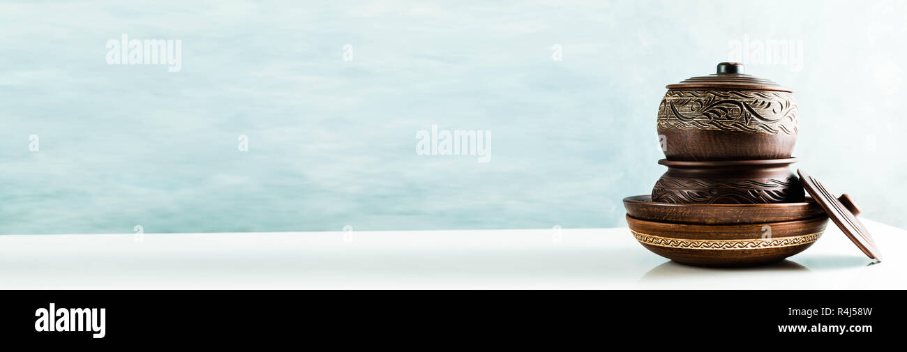 banner of pots and plates of clay on a white table and a blue ...