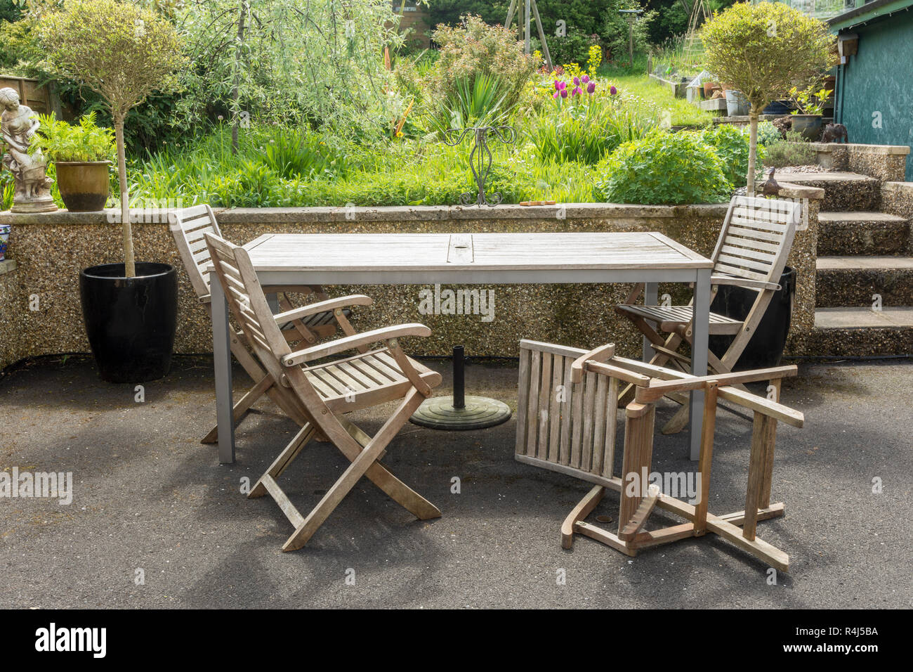 Garden table and chairs pushed over Stock Photo - Alamy