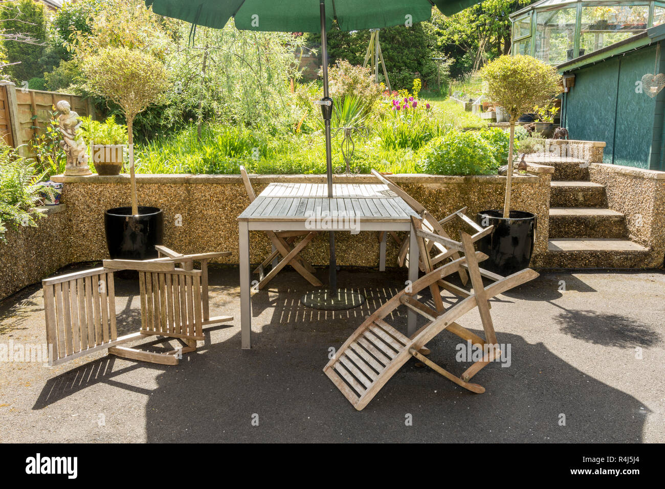 Garden table and chairs pushed over Stock Photo - Alamy