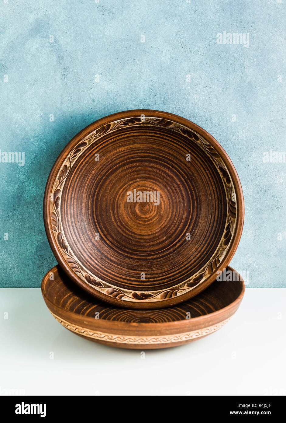 pots and plates of clay on a white table and a blue background. clay ...