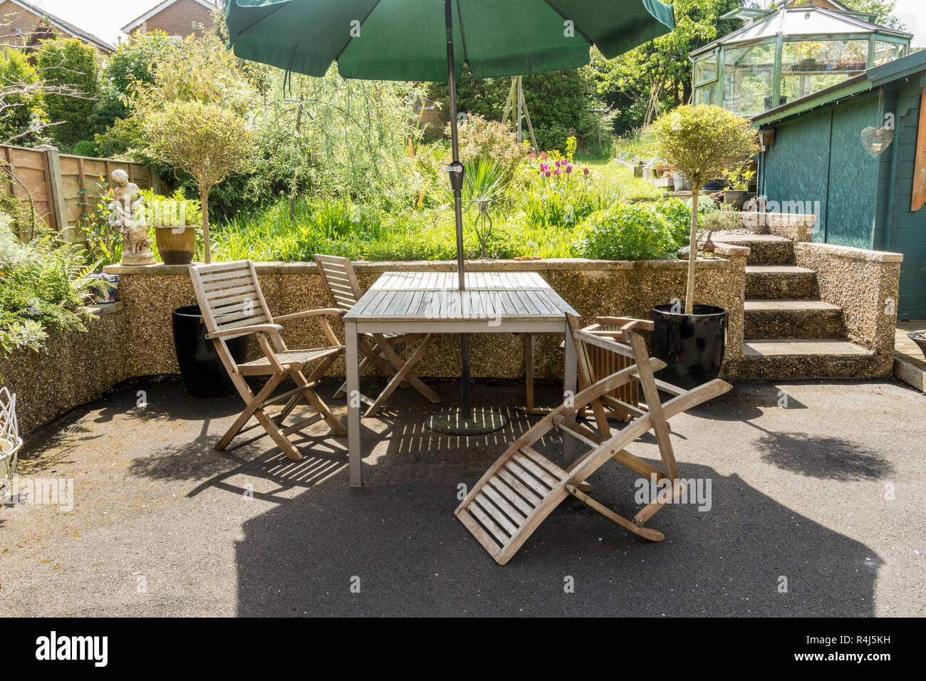 Garden table and chairs pushed over Stock Photo - Alamy