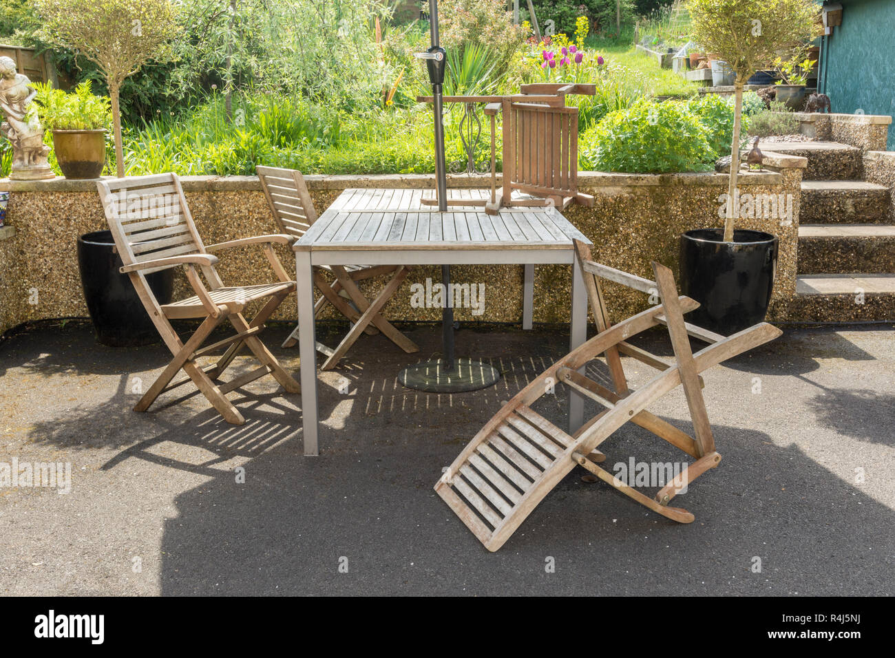 Garden table and chairs pushed over Stock Photo - Alamy