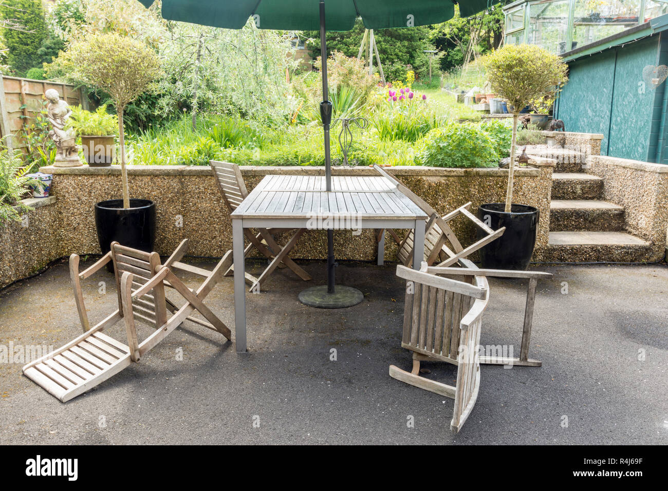 Garden table and chairs pushed over Stock Photo - Alamy