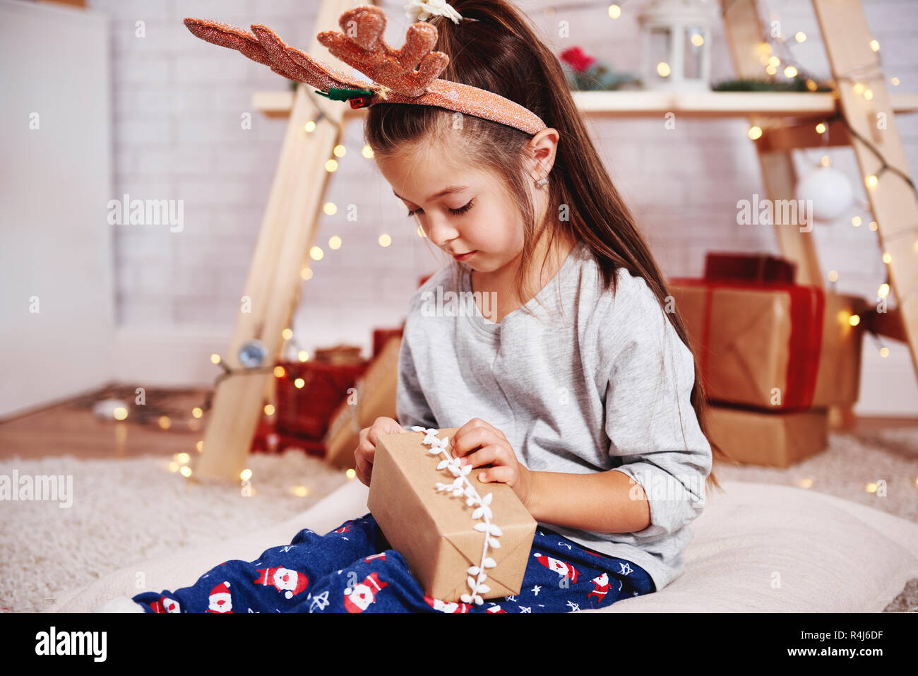 Cute girl opening christmas present Stock Photo - Alamy