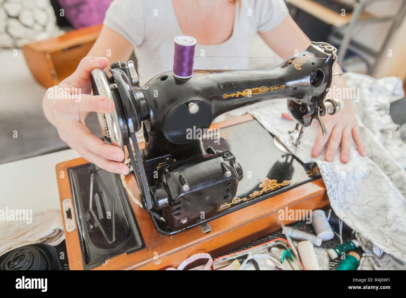 Female tailor hands using retro sewing machine for making dress at home ...