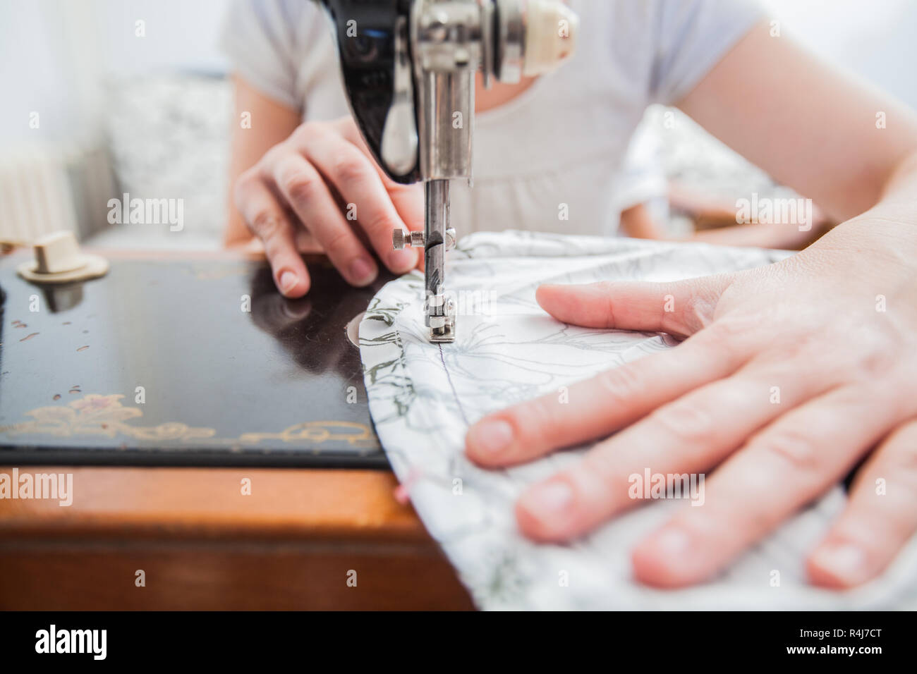 Female tailor hands using retro sewing machine for making dress at home ...