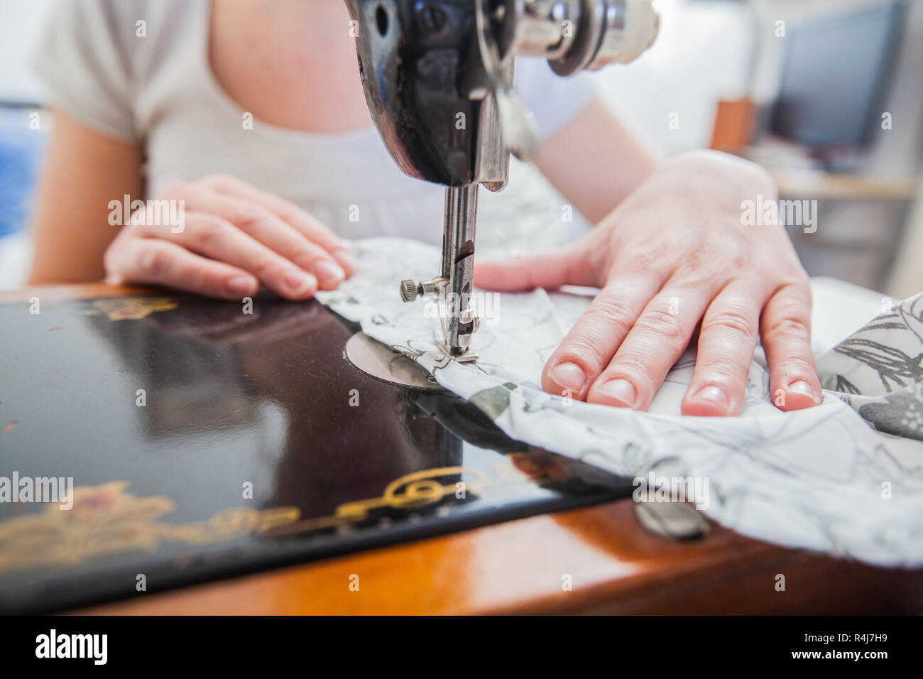 Female tailor hands using retro sewing machine for making dress at home ...