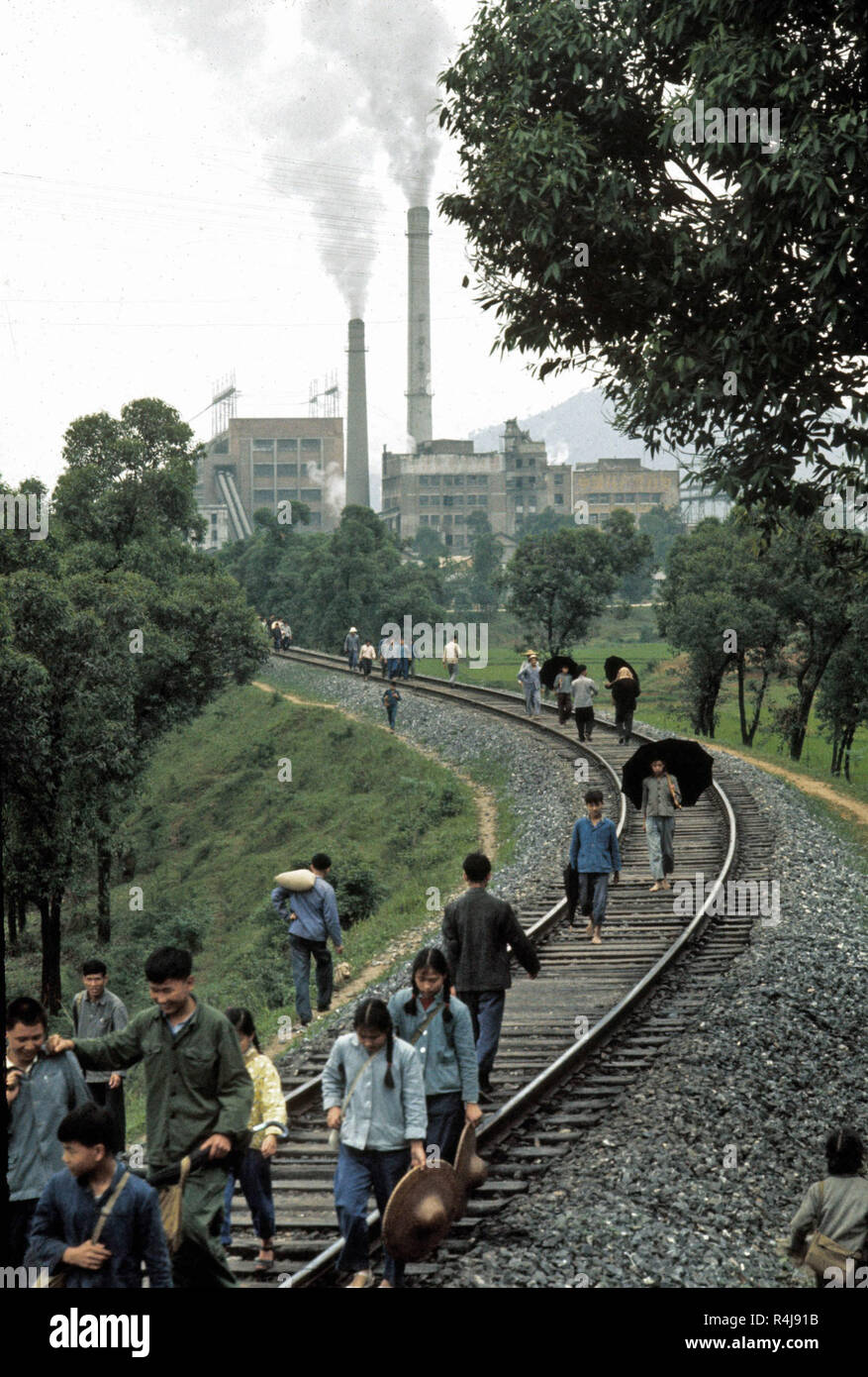 China 1973 factory workers leaving factory using the train track as a ...