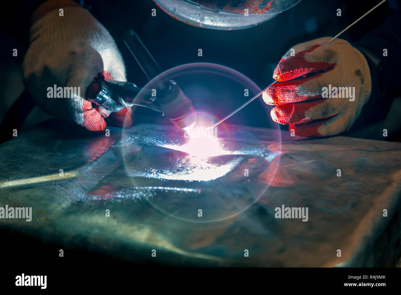 Argon-arc welding welder at the workplace welds the part Stock Photo ...