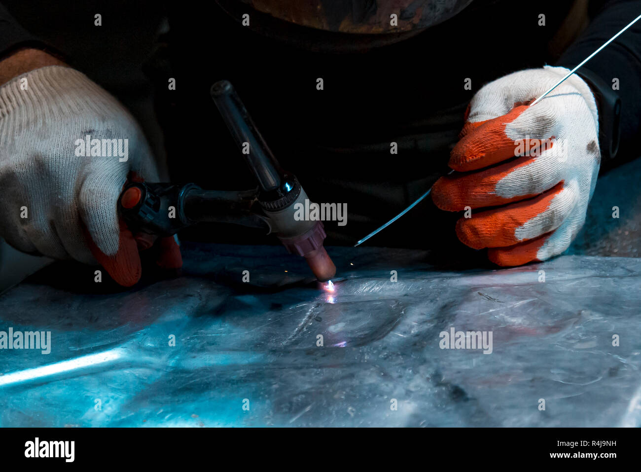 Argon-arc welding welder at the workplace welds the part Stock Photo ...
