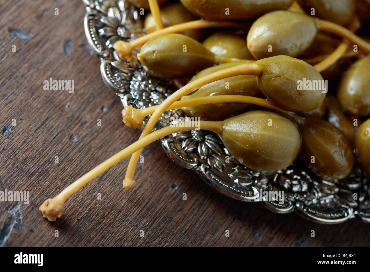 Pickled caper berries in metal dish . Edible fruits of Capparis ...