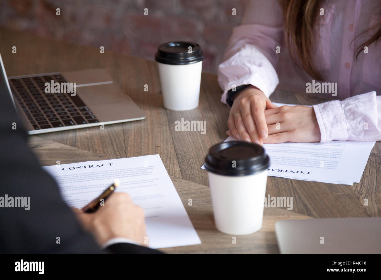 Man in suit signs contract with a business partner Stock Photo - Alamy