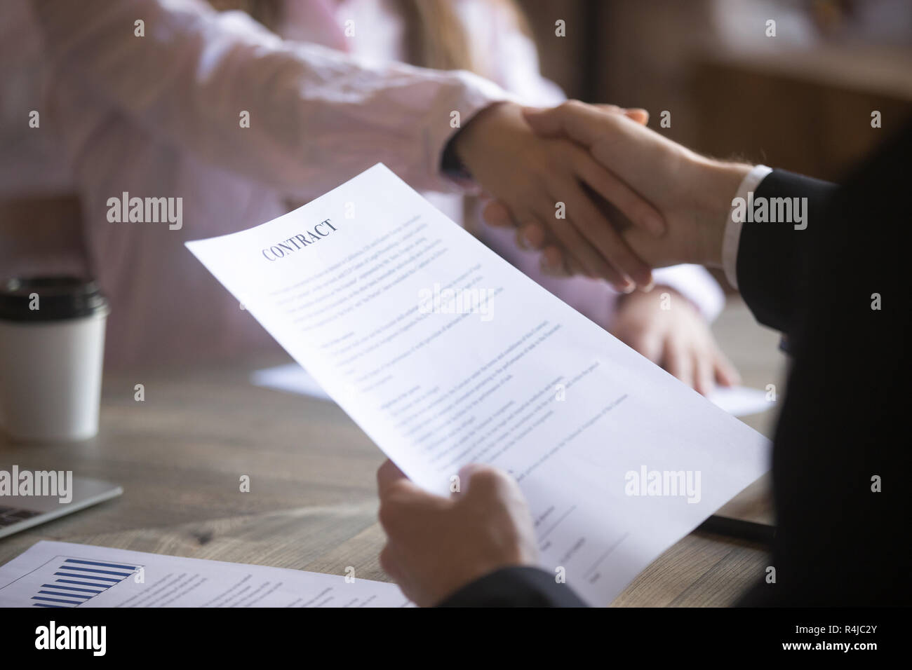Business partners handshaking after signing a contract Stock Photo - Alamy