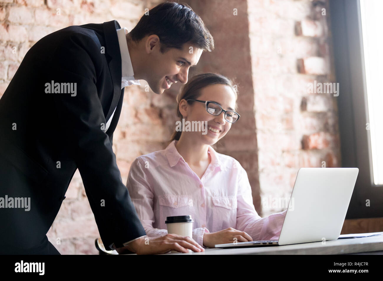 Happy employee looking at laptop screen and smiling Stock Photo - Alamy