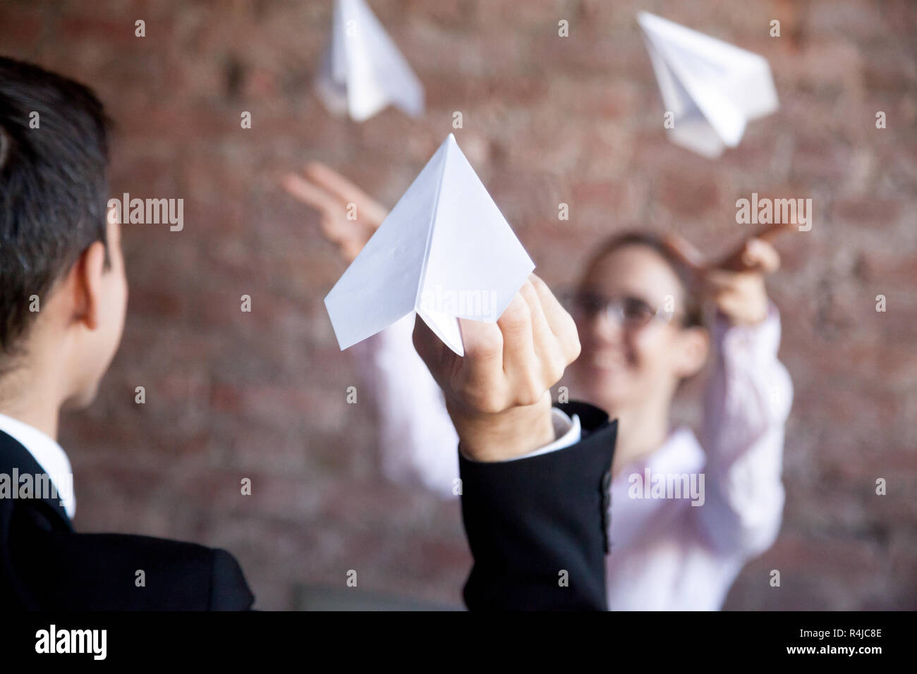 Office workers launching paper planes together in office Stock Photo ...