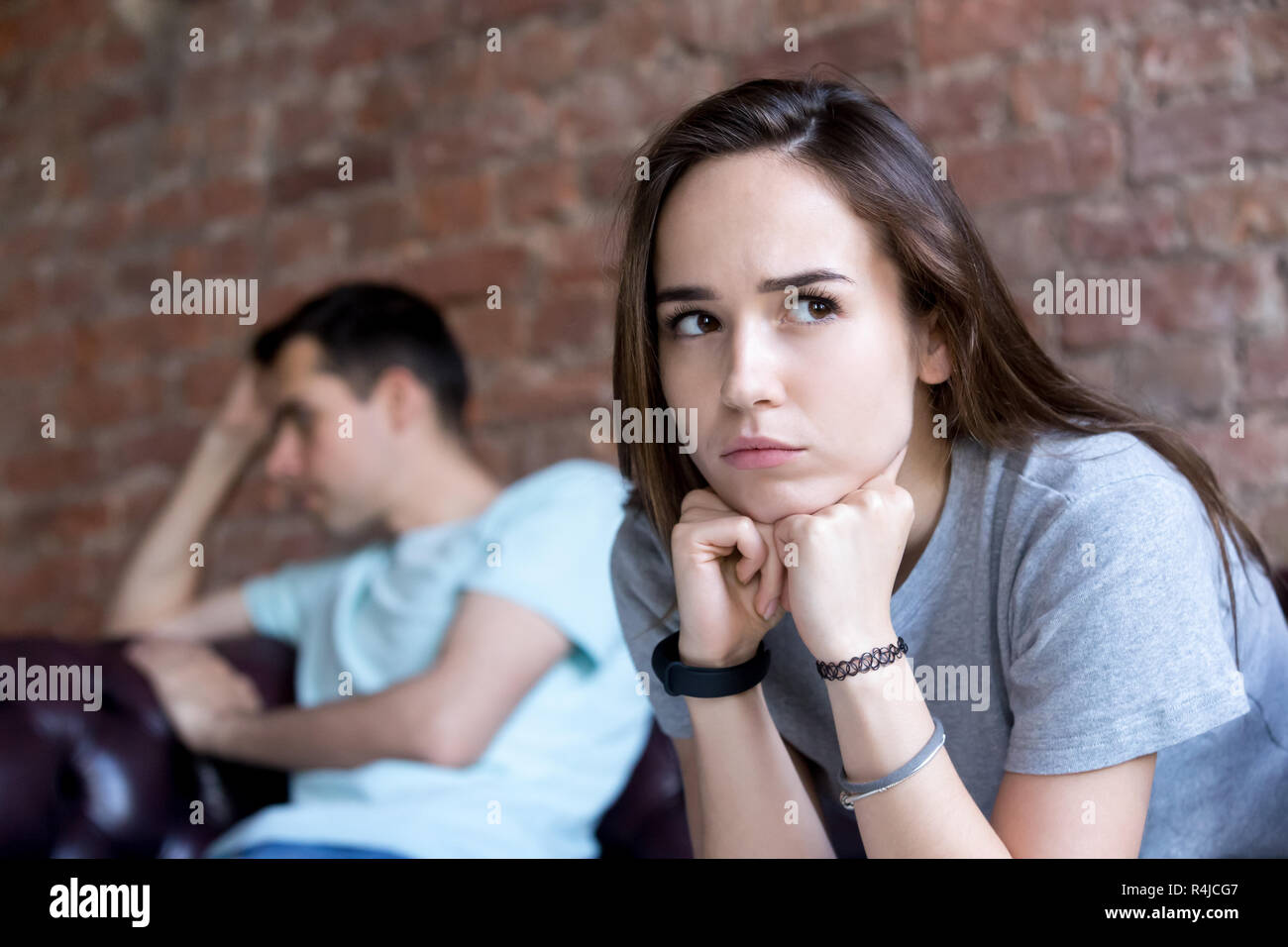 Offended man and woman are seated separately on sofa Stock Photo - Alamy
