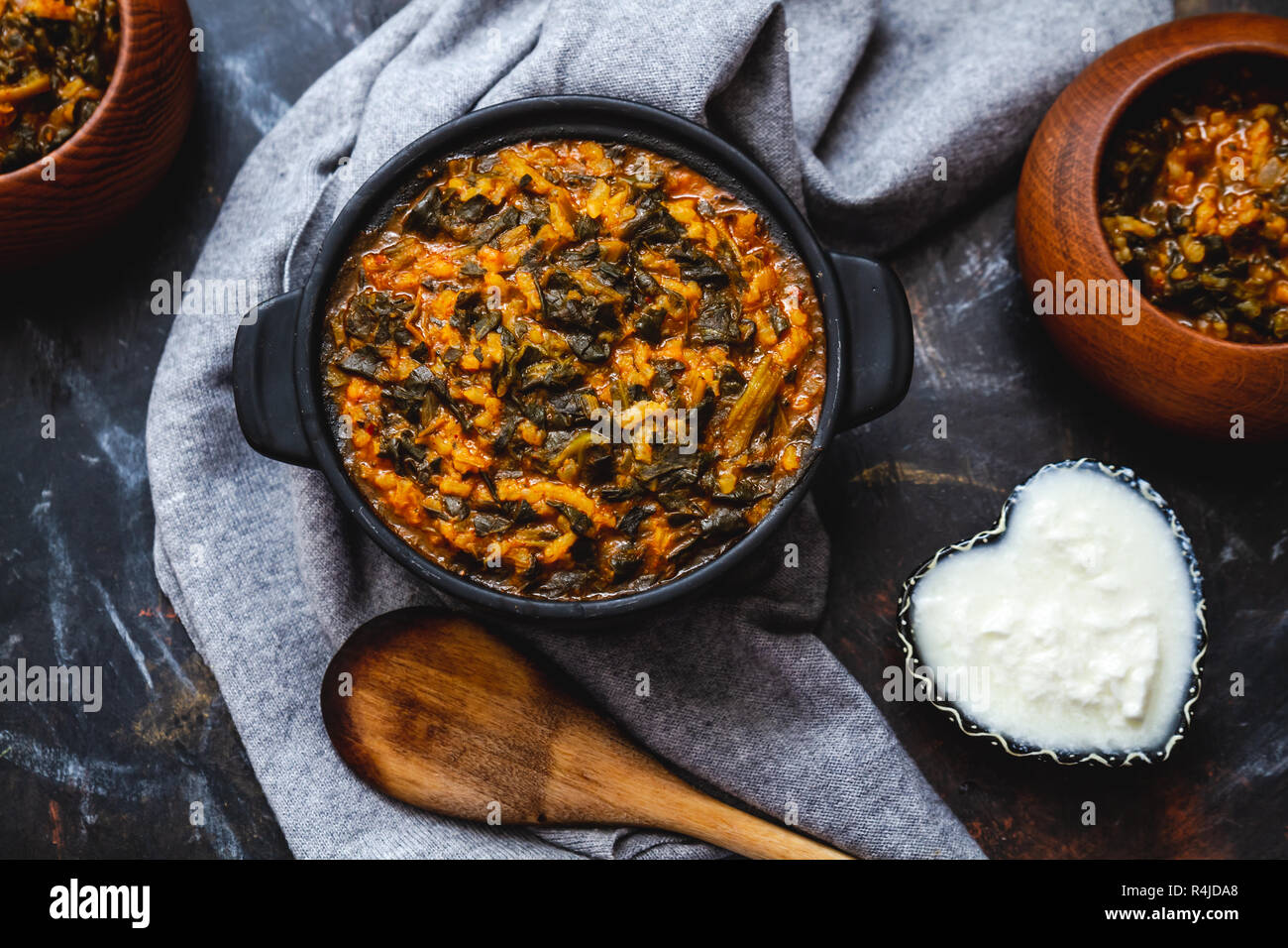 Spinach stew with rice in black pot on dark background Stock Photo - Alamy