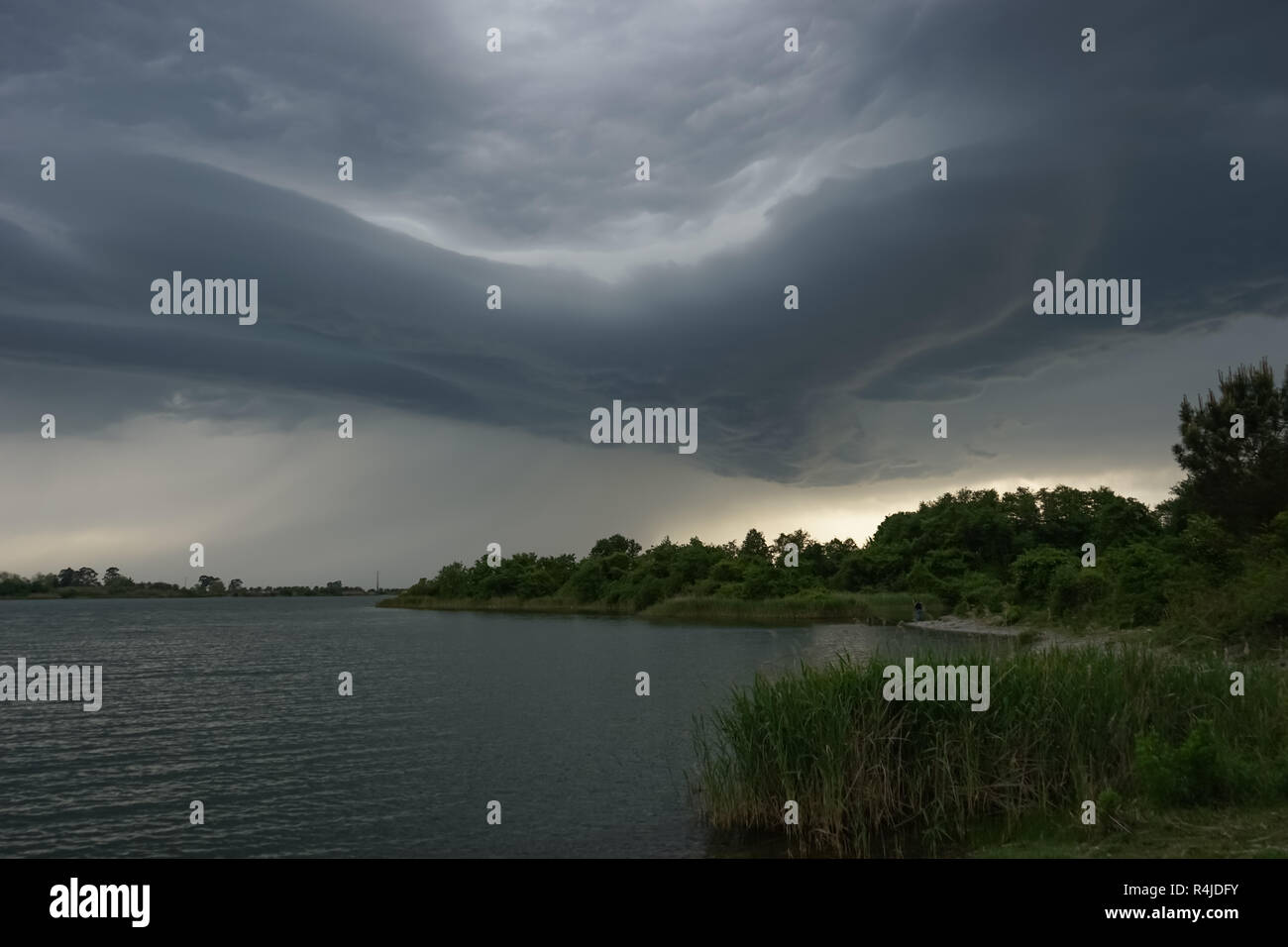 Dramatic landscape with storm clouds over the lake Stock Photo - Alamy