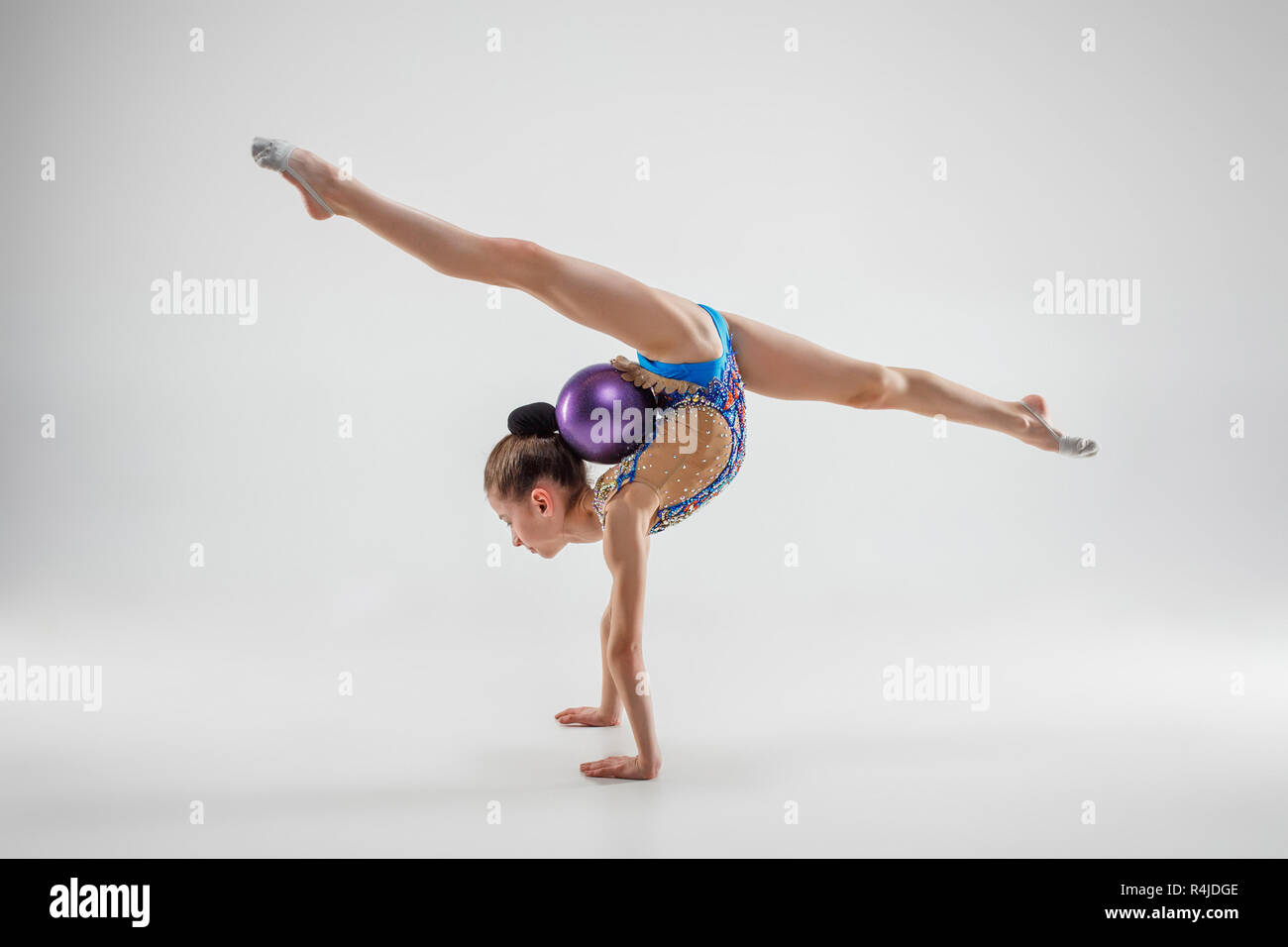 The teen female little girl doing gymnastics exercises isolated on a ...
