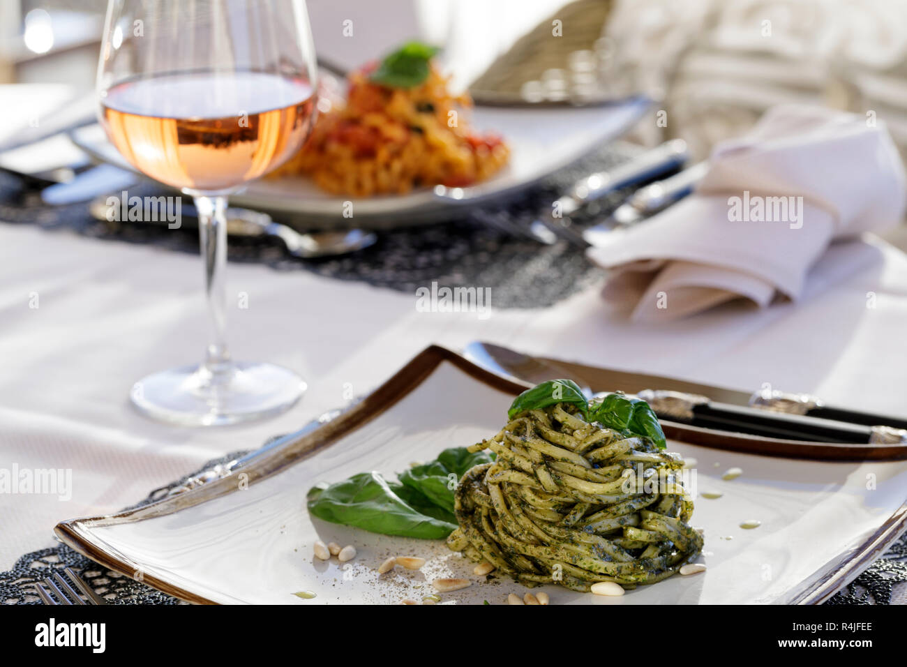Light pasta pesto lunch with glass of rose wine Stock Photo - Alamy