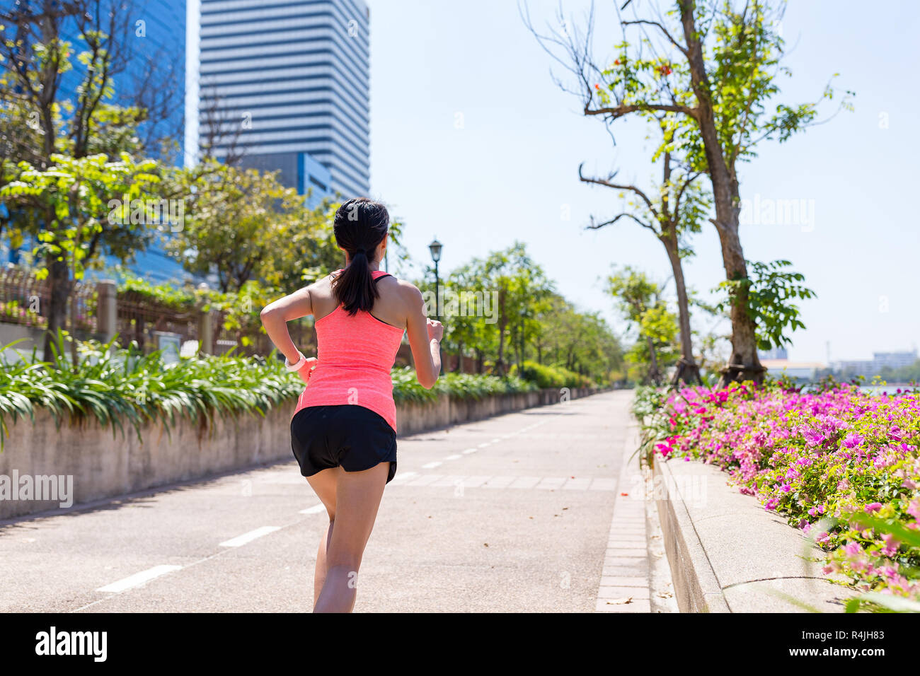 Back view of woman running at park Stock Photo - Alamy