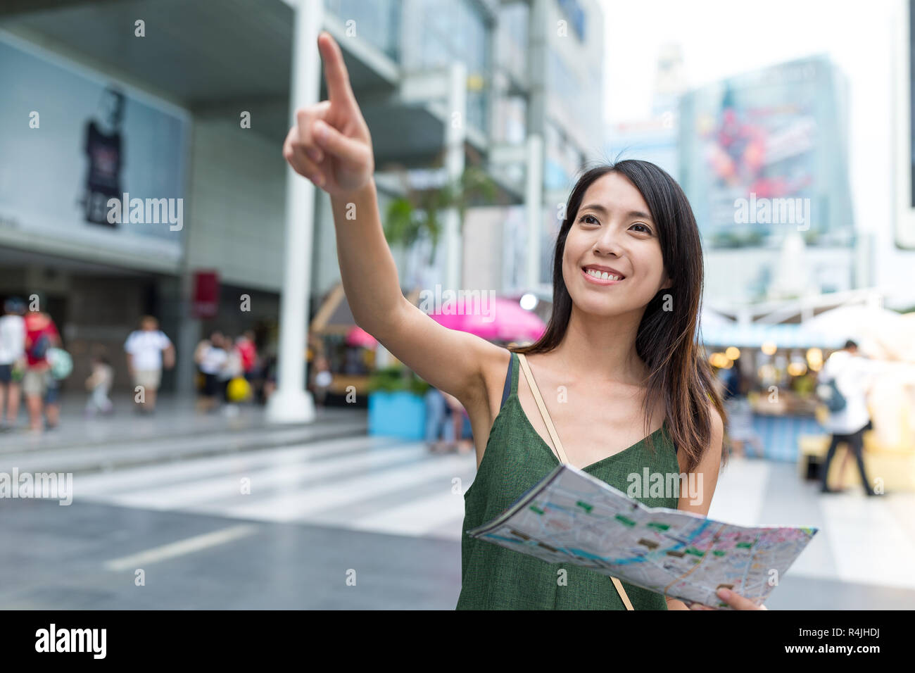 Woman using city map and finger pointing far away Stock Photo - Alamy