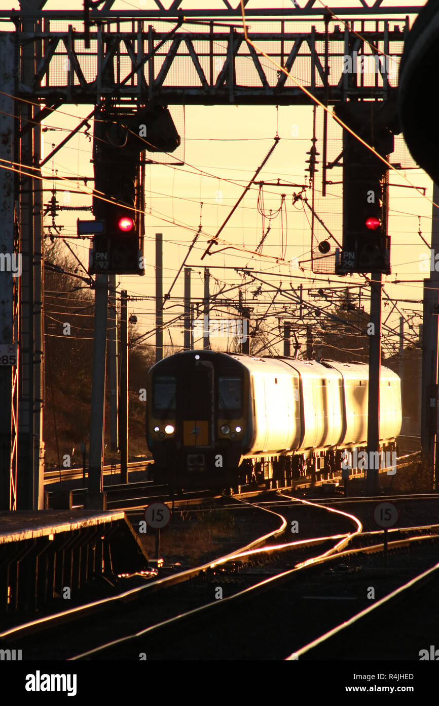 Glint of sunlight off side of class 350 electric multiple unit passing ...