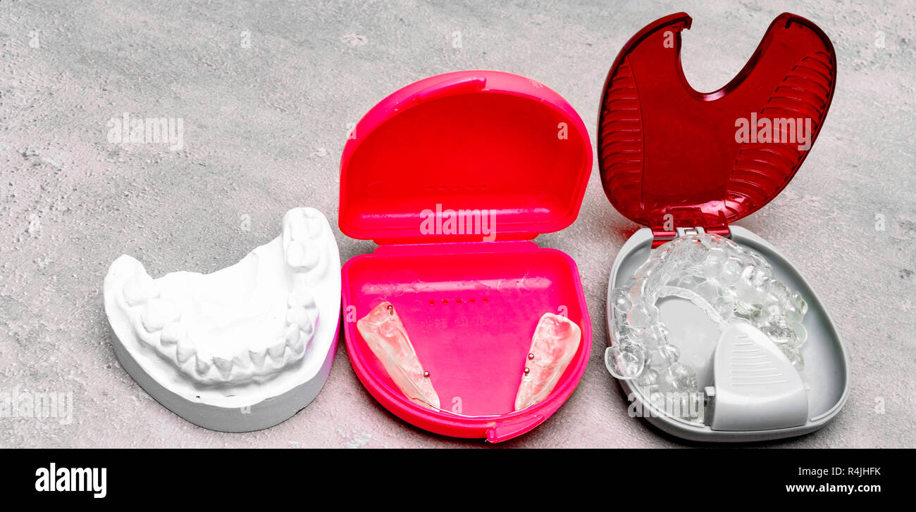 gypsum cast, different aligners clear and in box on grey stone ...