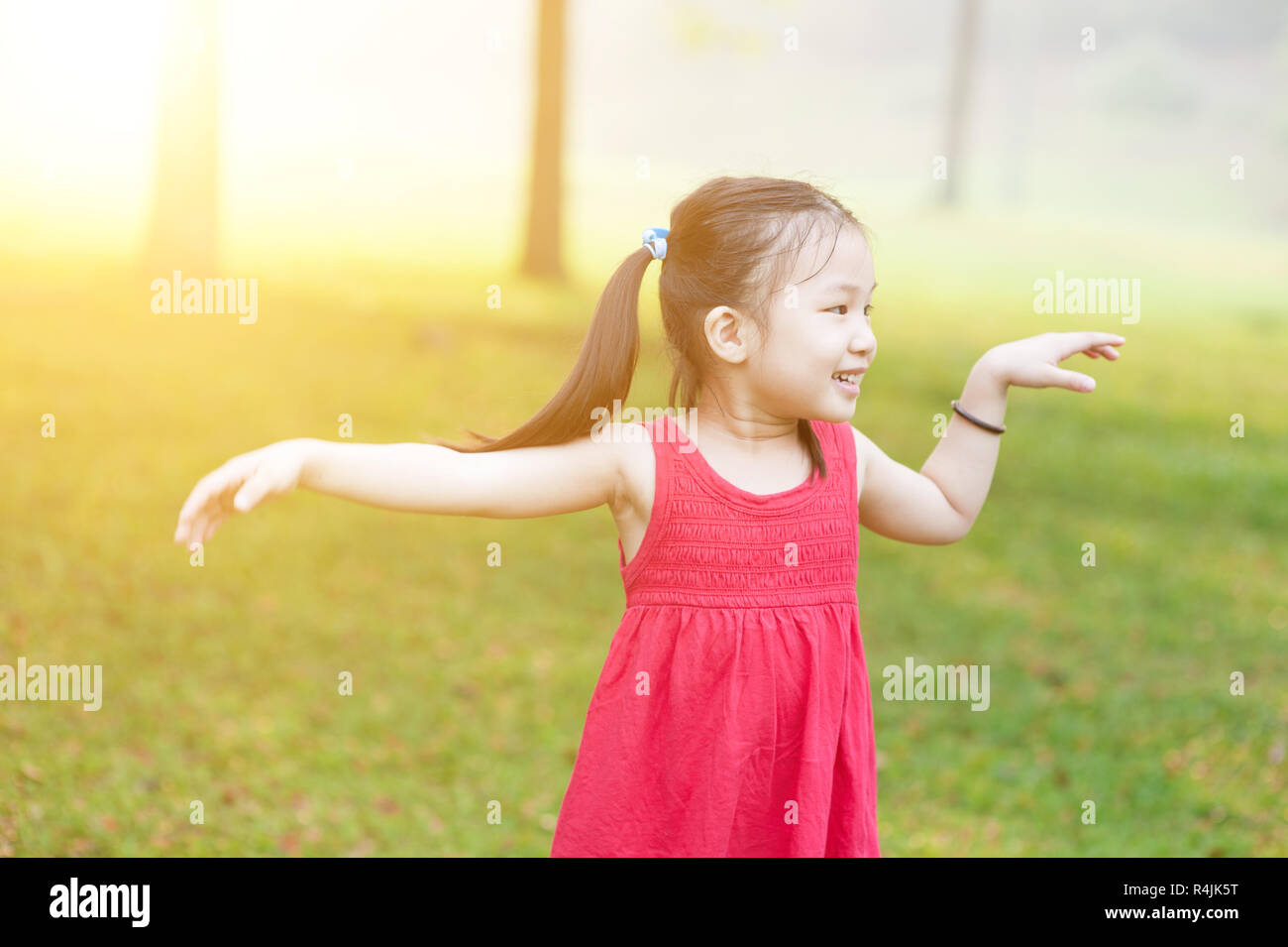 Asian child dancing outdoors Stock Photo - Alamy