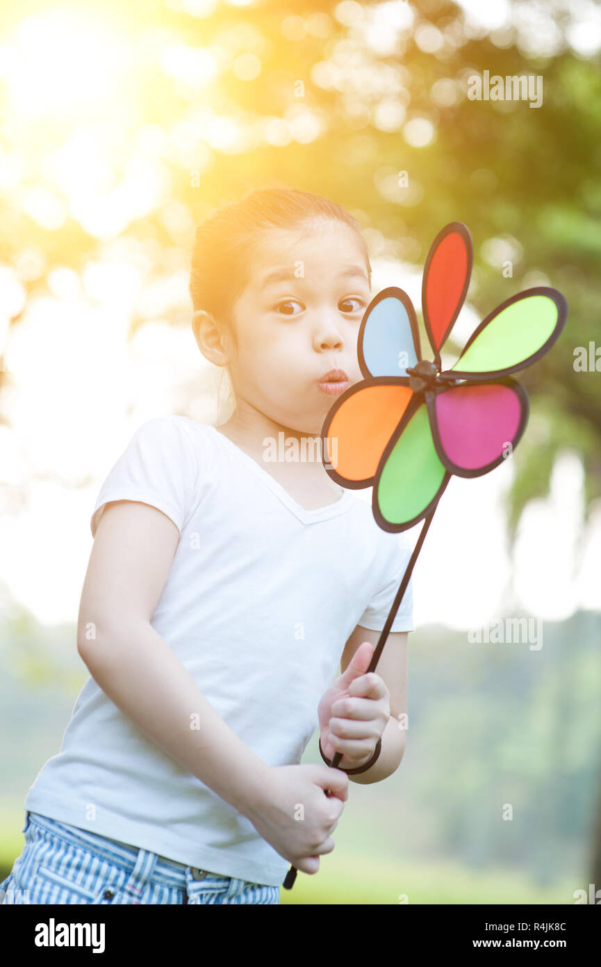 Asian child blowing windmill outdoors Stock Photo - Alamy