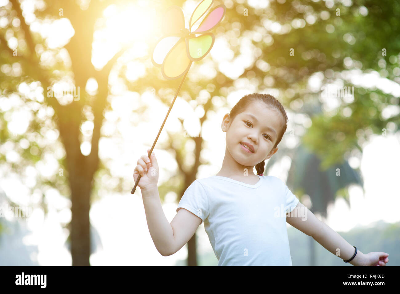 Asian child playing windmill outdoors Stock Photo - Alamy