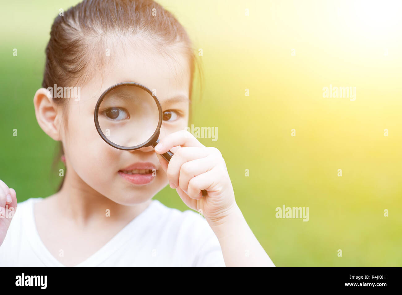 Asian kid with magnifier glass at outdoors Stock Photo - Alamy
