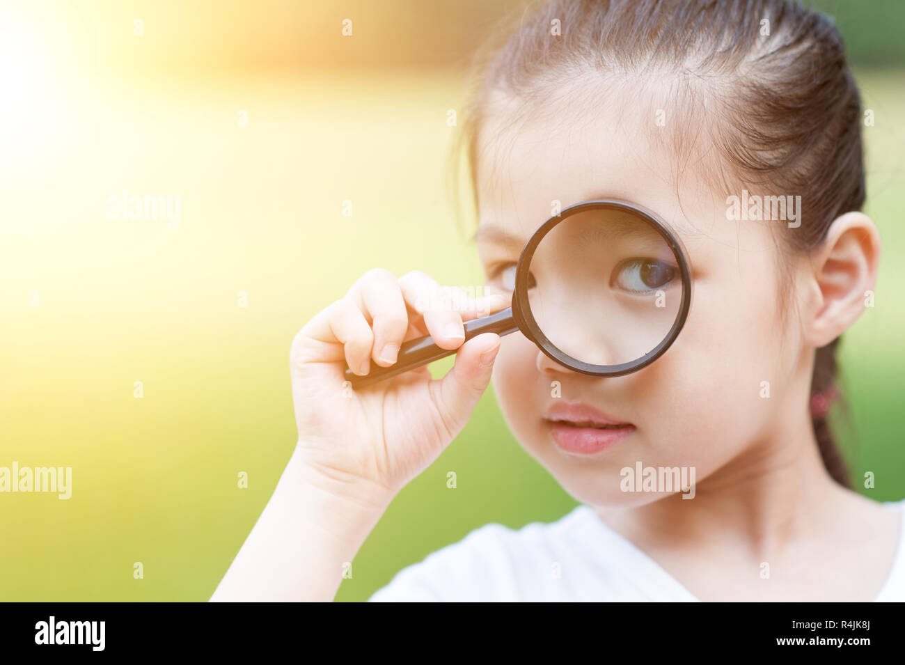 Asian child with magnifier glass at outdoors Stock Photo - Alamy