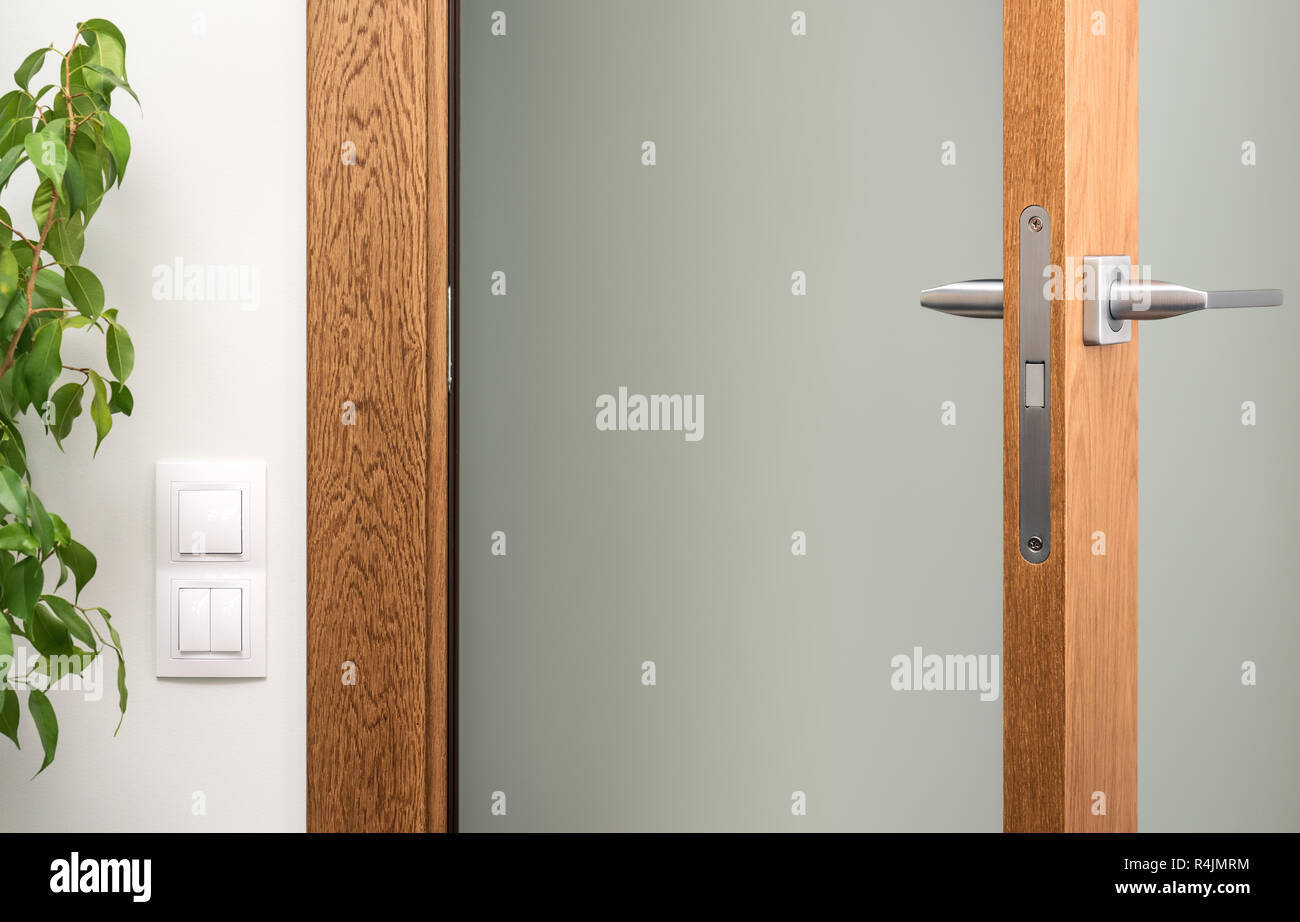 Open interior door. Close-up of door handle and lock. White switches on ...