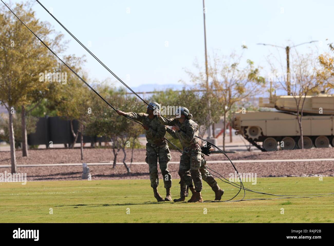 Air Assault students hold ropes hanging from a UH-60 Black Hawk ...