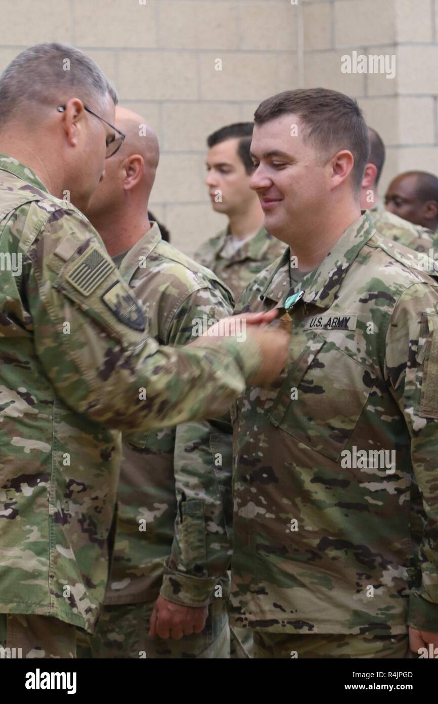 Staff Sgt. Jeffrey Grimes receives the Army Commendation Medal from ...