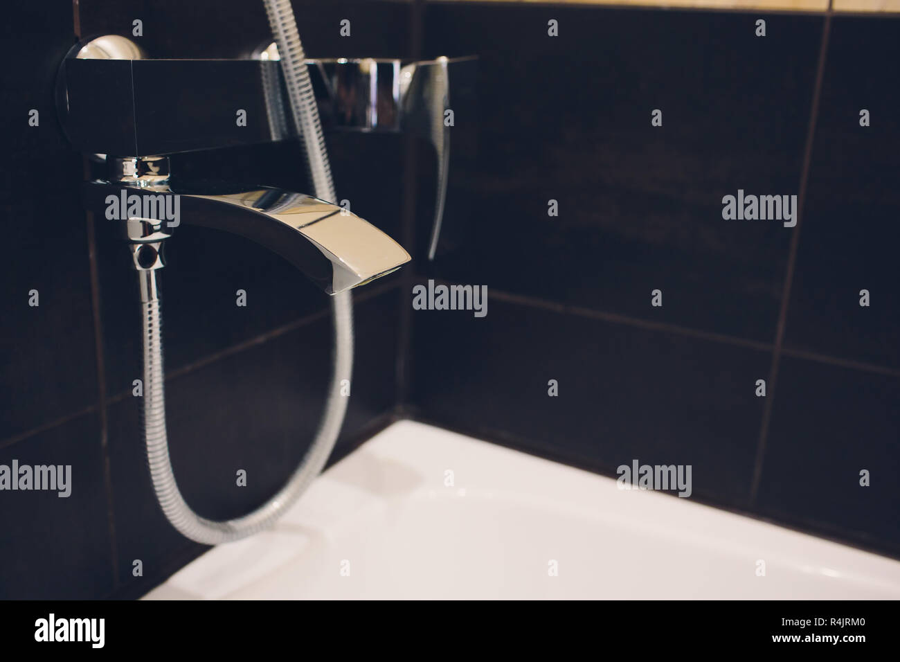 Water running from shower head in bathroom with dark black background ...