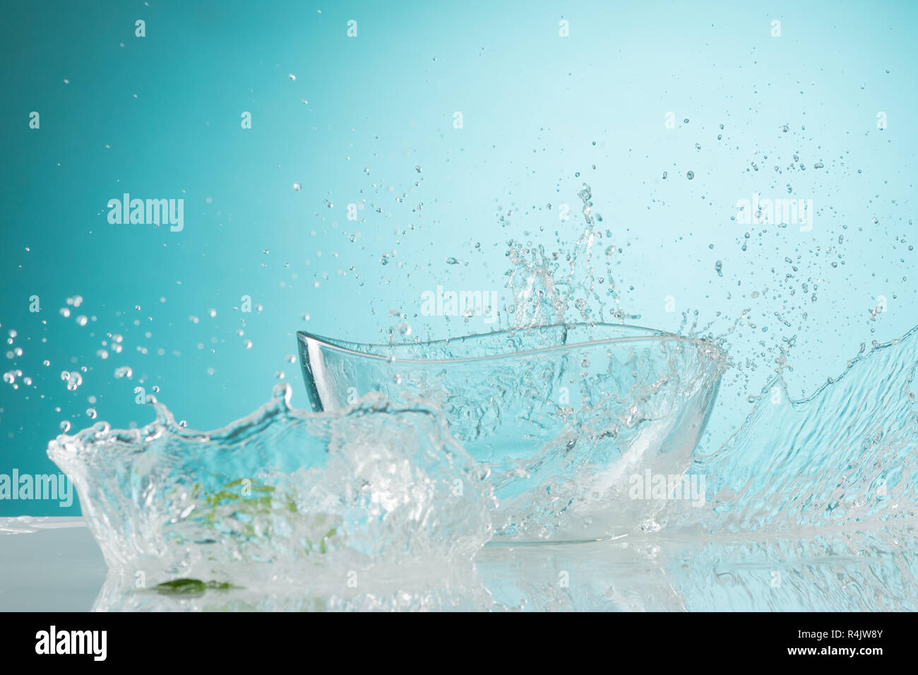 The water splashing to glass bowl on white background Stock Photo - Alamy