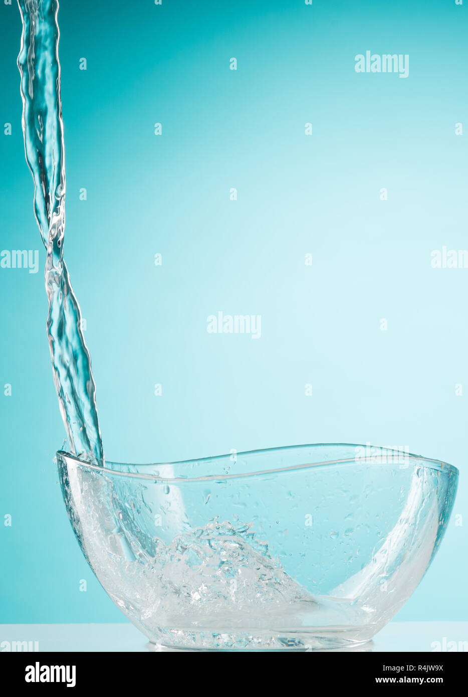 The water splashing to glass bowl on white background Stock Photo - Alamy
