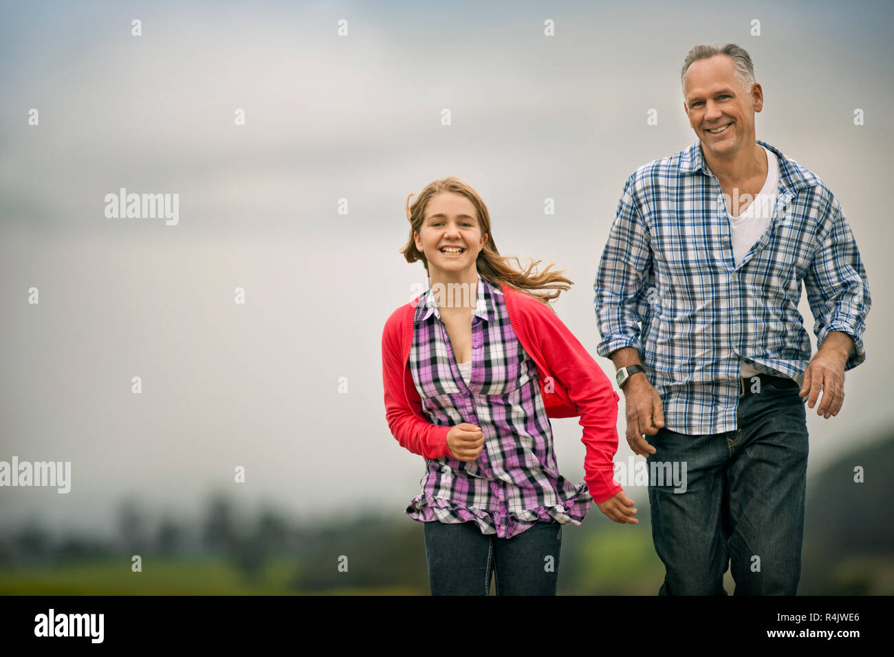 Portrait of a smiling father and daughter running side by side Stock ...