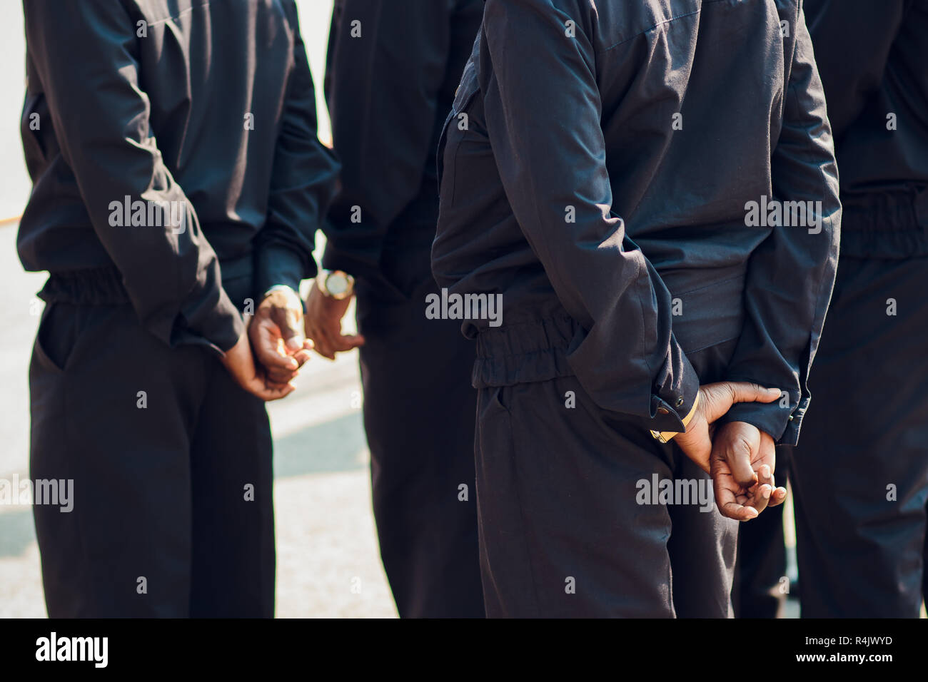 Legs police men guard on the construction rear view dark hands. African ...